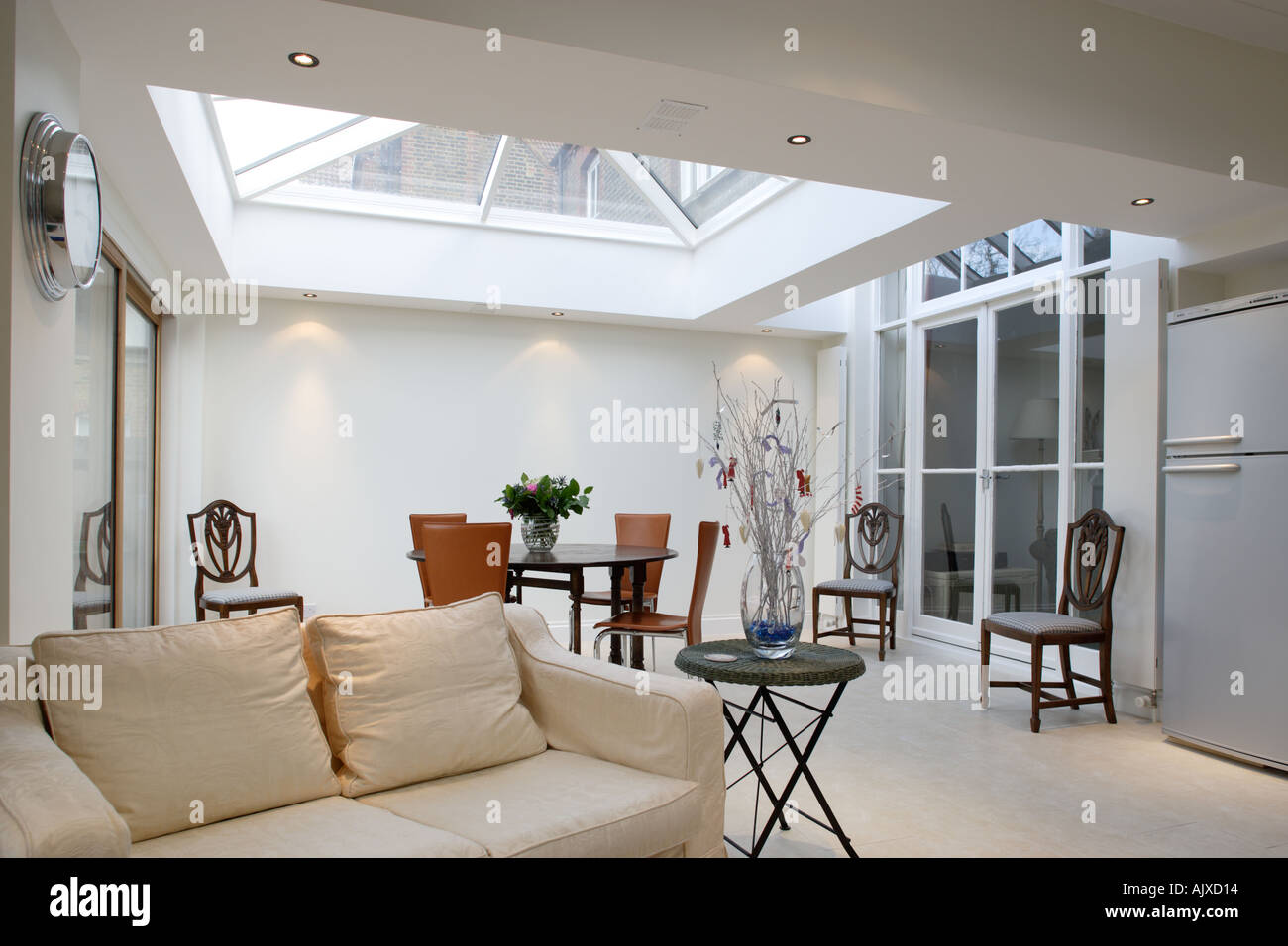 Dining room with roof lantern and glass doors to garden Stock Photo - Alamy