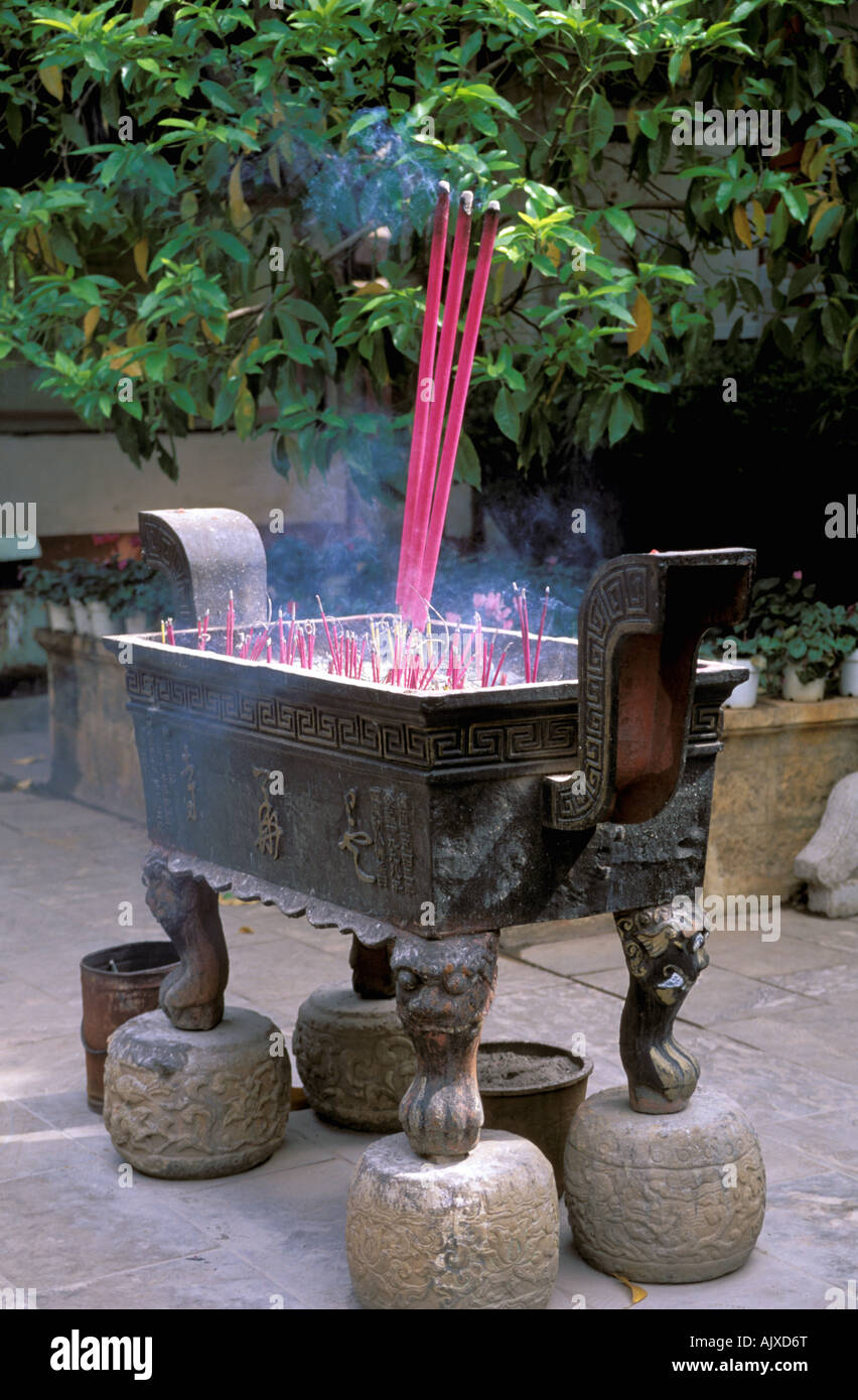 Asia, China, Yunnan Province, Kunming. Incense burns in Buddhist urn ...