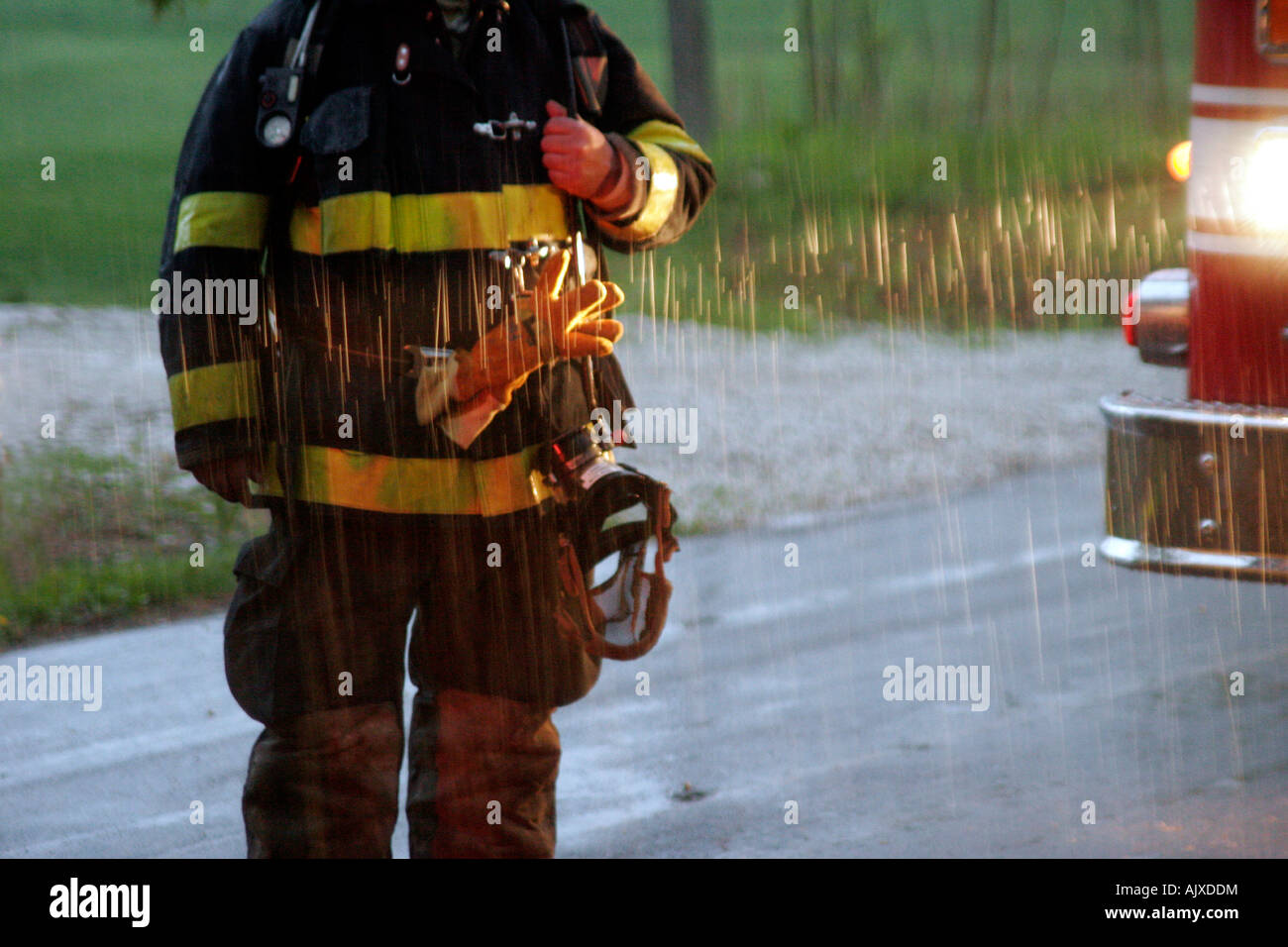 Fire Fighter standing in the rain at a fire scene Stock Photo - Alamy