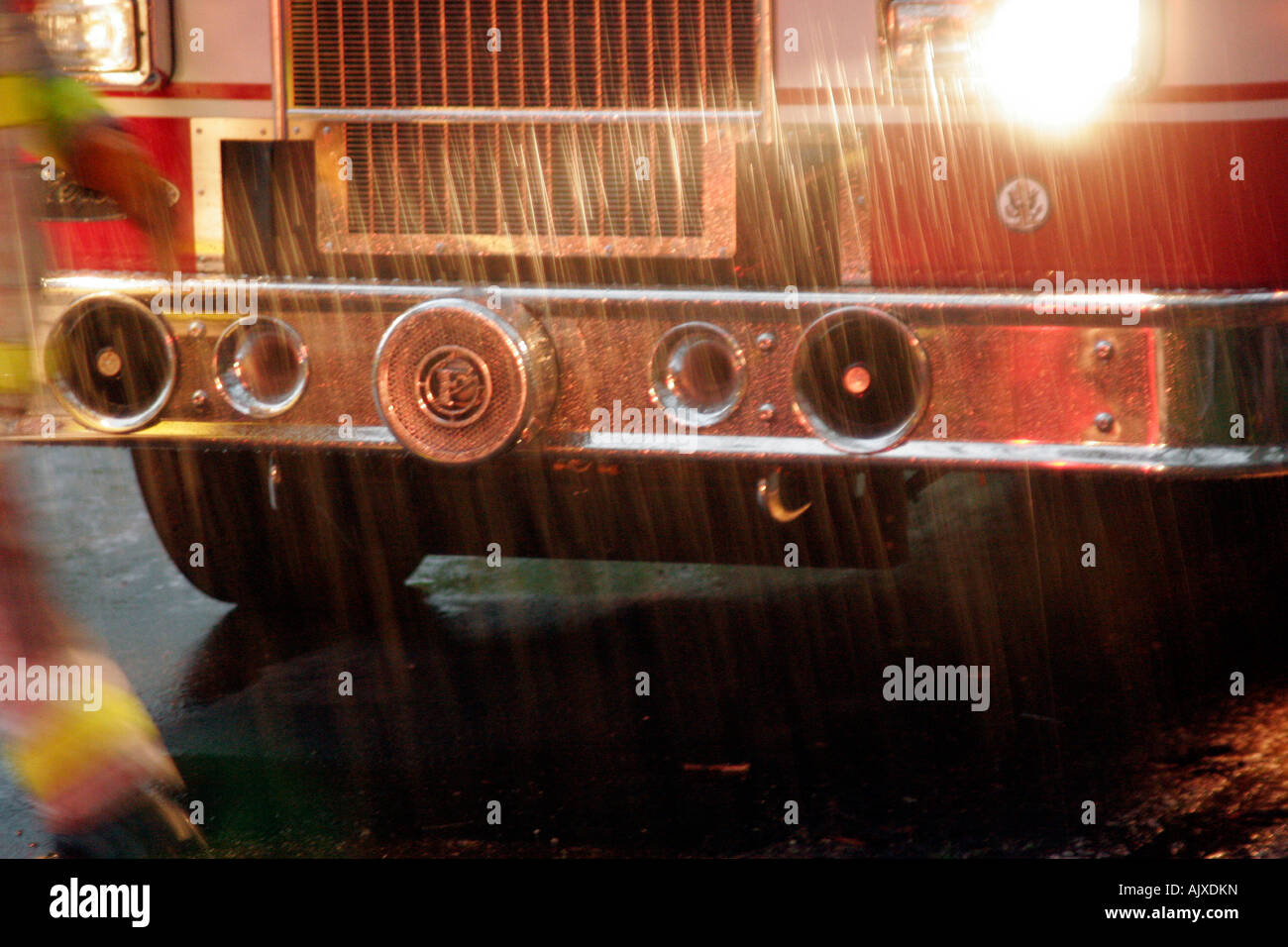 Fire engine in the rain at an emergency scene with a fire fighter ...