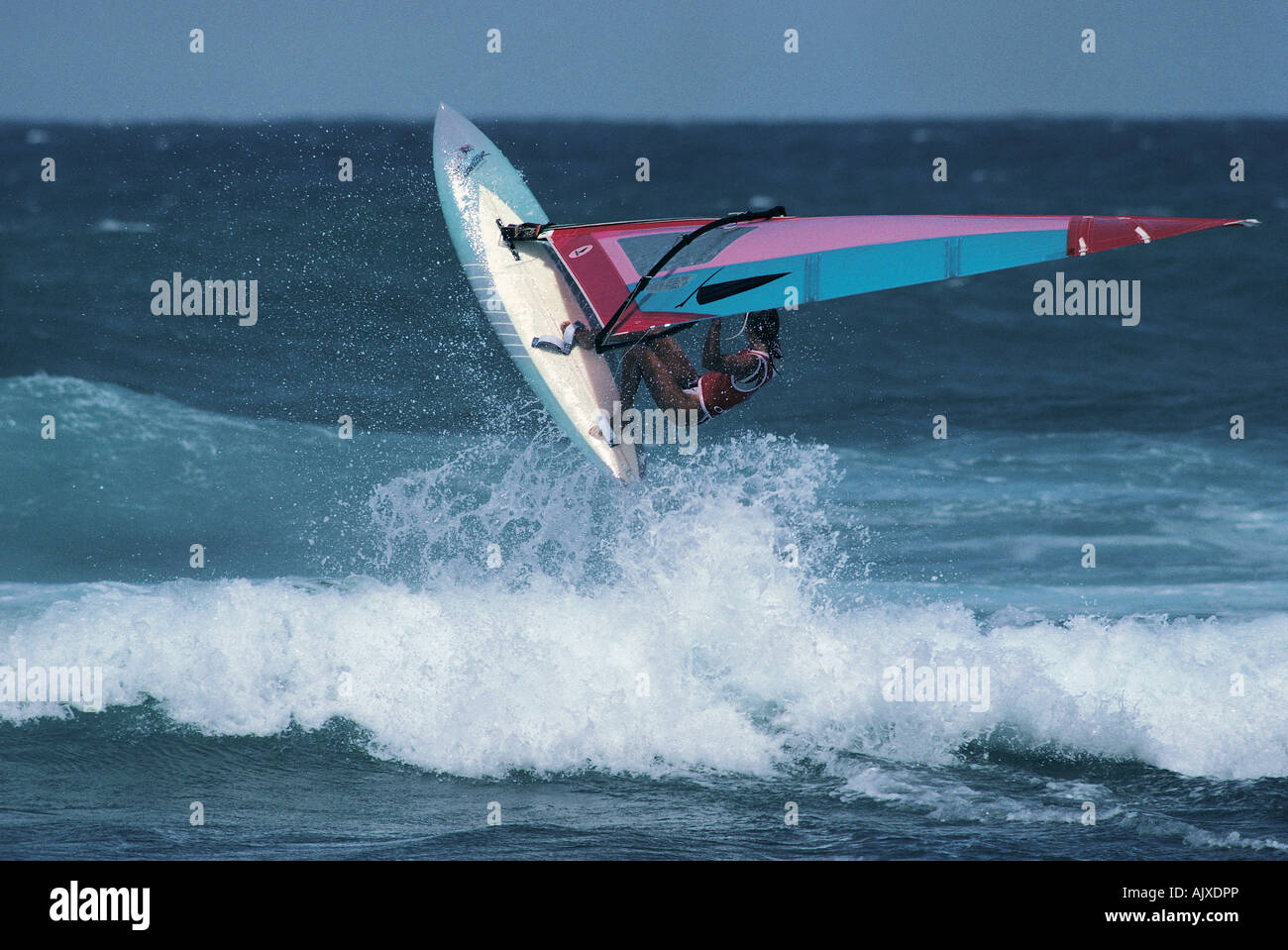 Young woman windsurfing. Jumping wave Stock Photo - Alamy