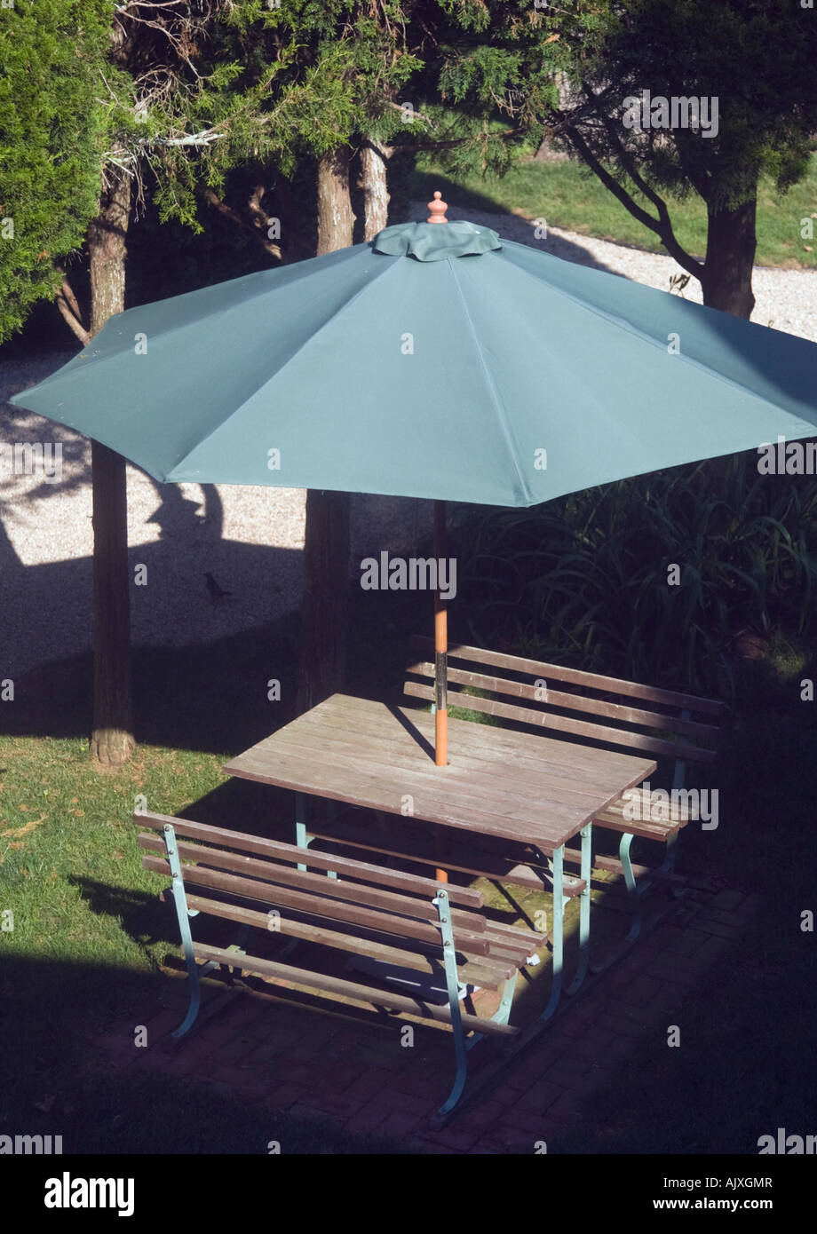 Table and bench under an umbrella Stock Photo - Alamy