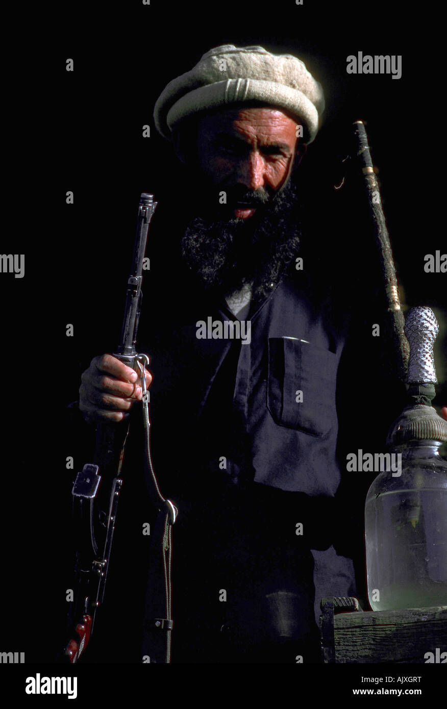 An Afghan fighter with water pipe for smoking hashish and Kalashnikov ...