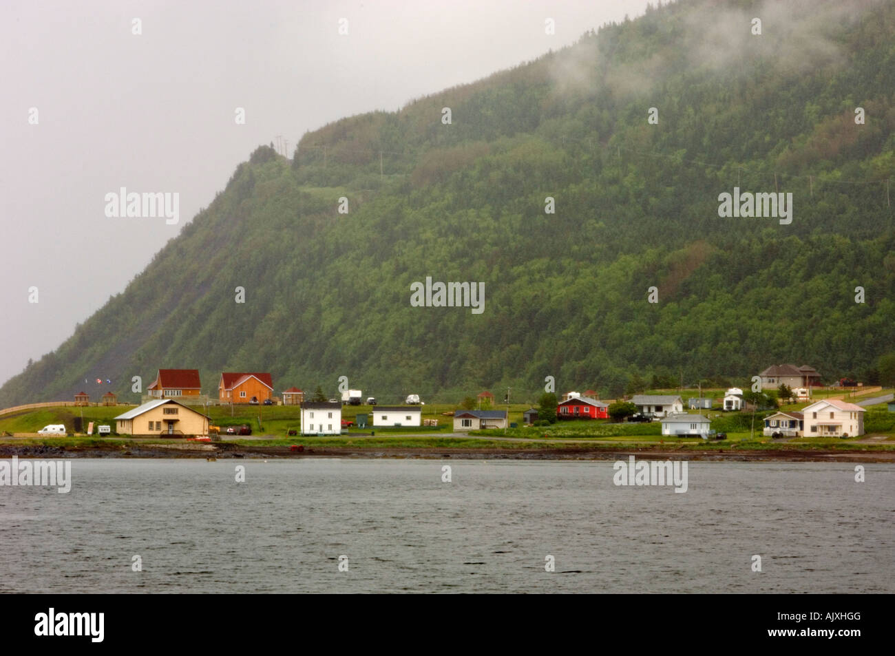 Fog-shrouded mountain slope overlooking town buildings along St ...