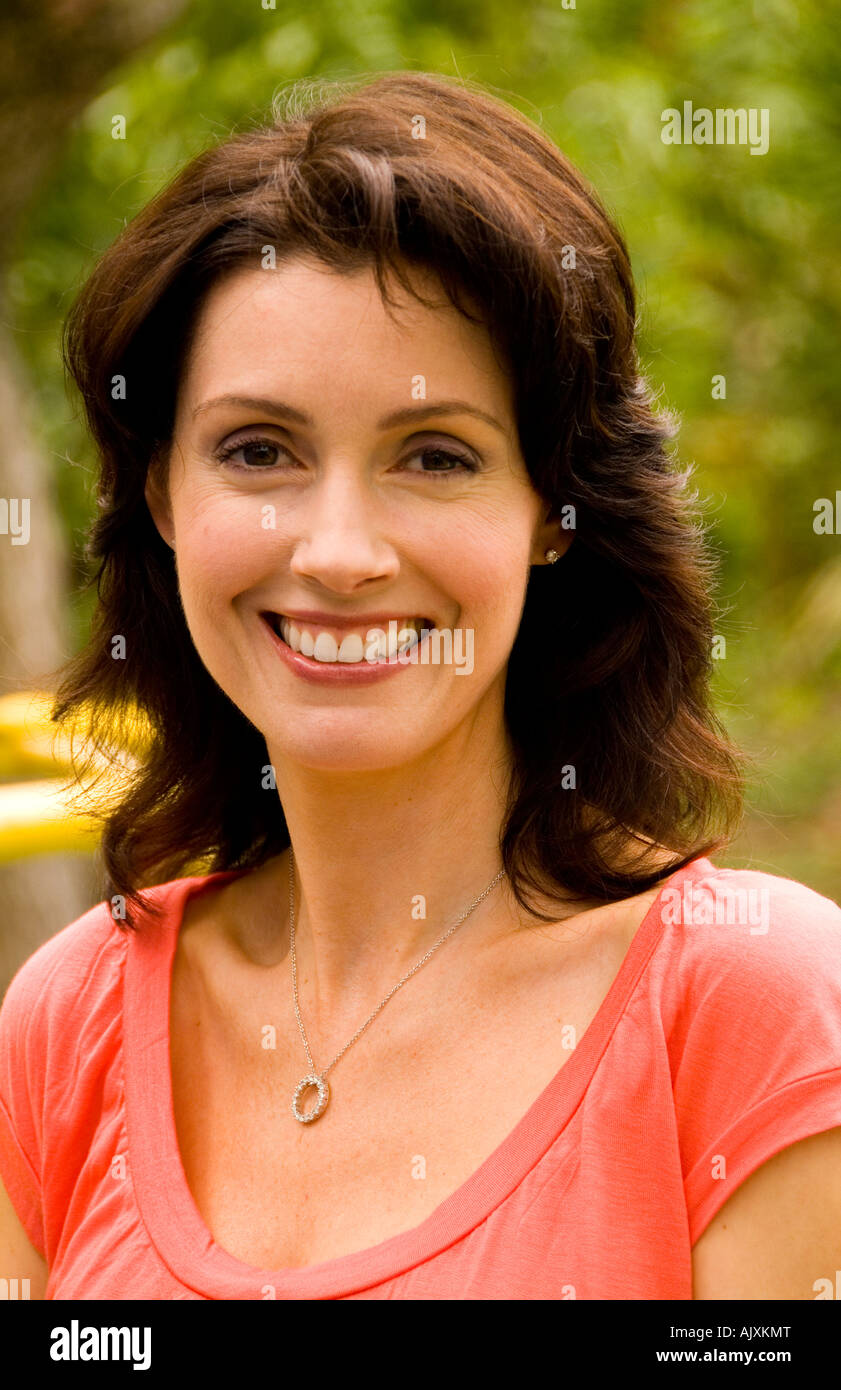 Portrait outdoors af attractive woman in her 30s smiling testimontial ...