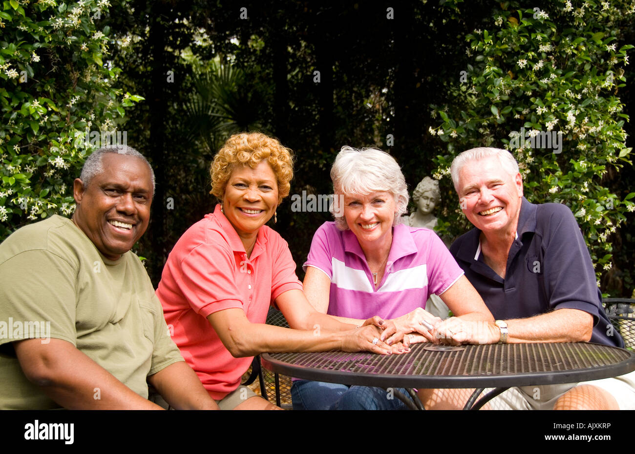 Retires senior friends of mixed races having a drink outdoors and ...