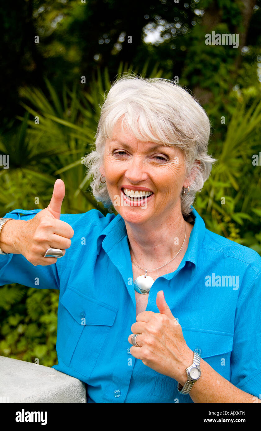 Attractive colorful woman in her 60s smiling outdoors and happy Stock ...