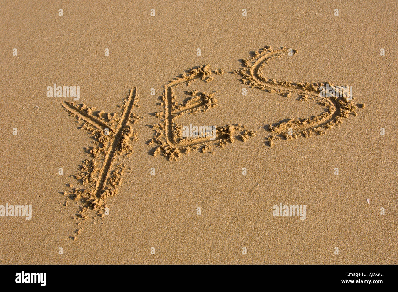 Yes written on sand Stock Photo - Alamy
