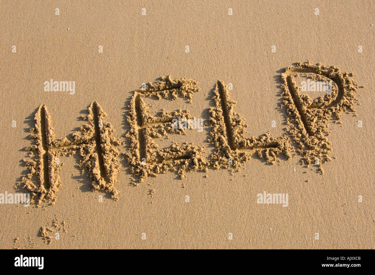 Help written on sand Stock Photo - Alamy