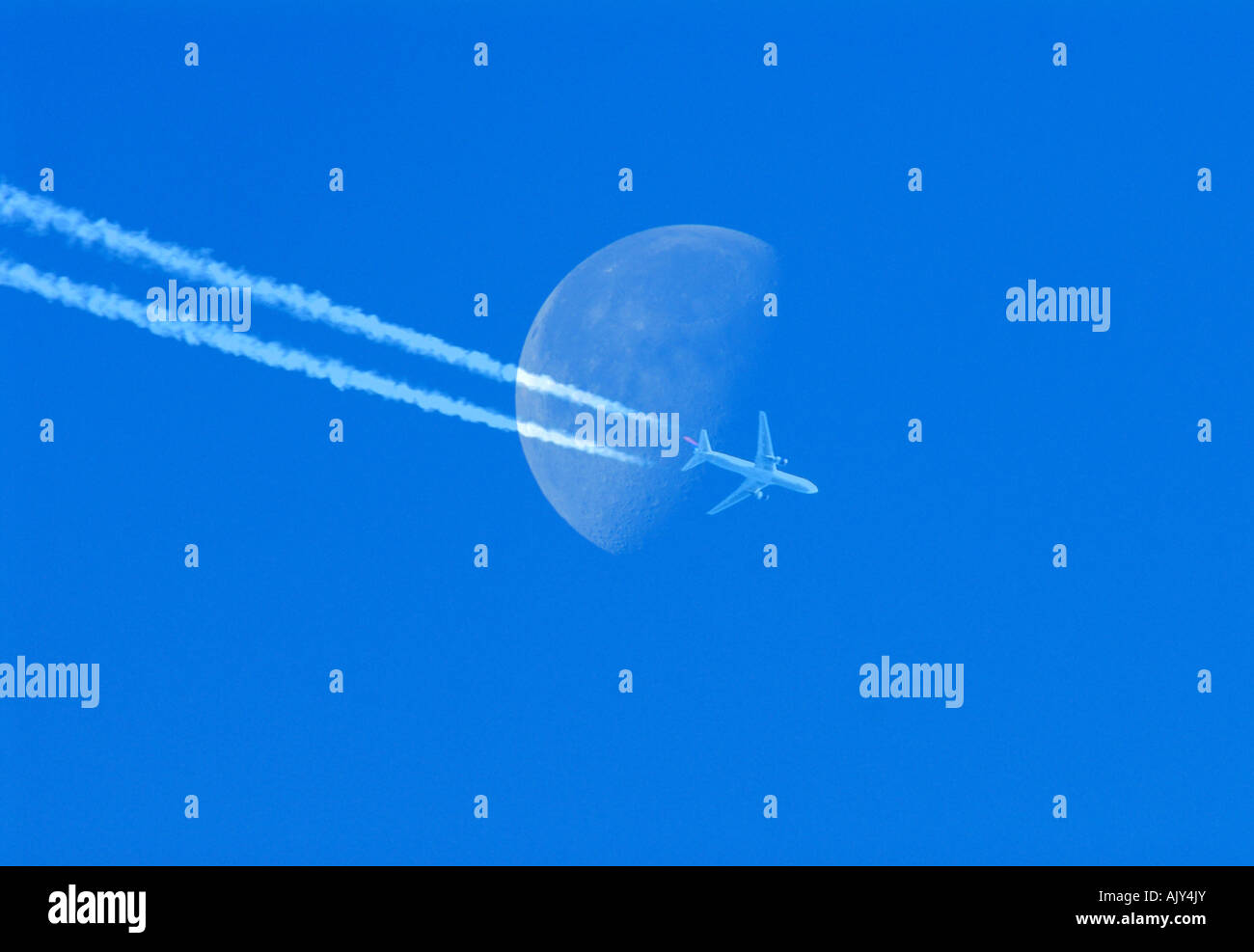 A plane passes the moon in the sky during a late summer evening Stock ...