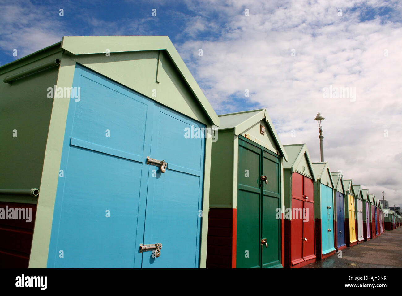 Brightly coloured beach huts in a row on Brighton seafront, England, UK ...