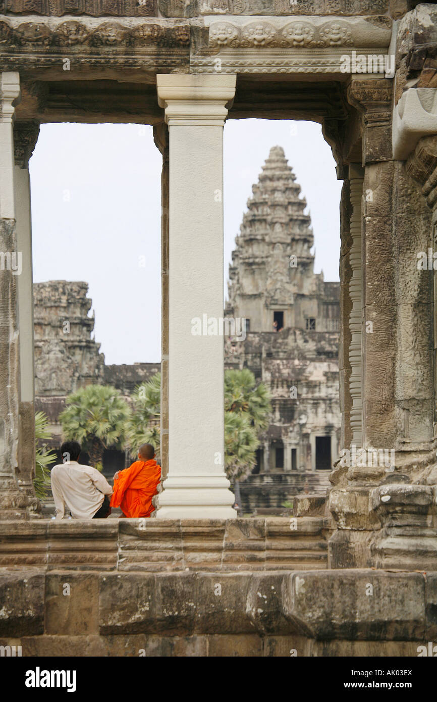 A monk and a friend sit framed by the exquisite architecture at Angkor ...