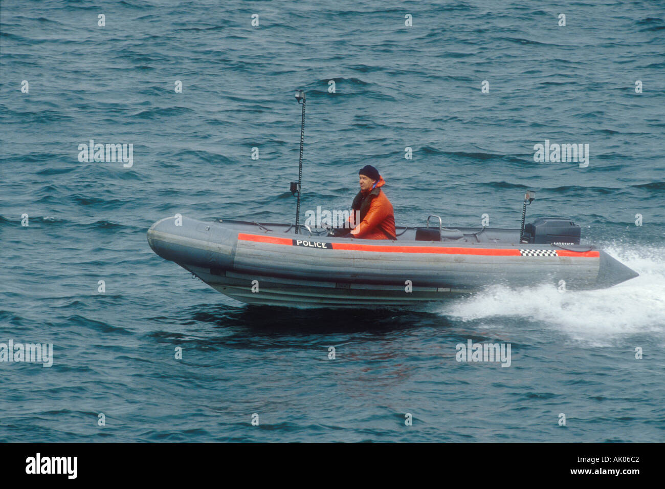 A police officer on patrol at sea in a rigid inflatable boat at ...