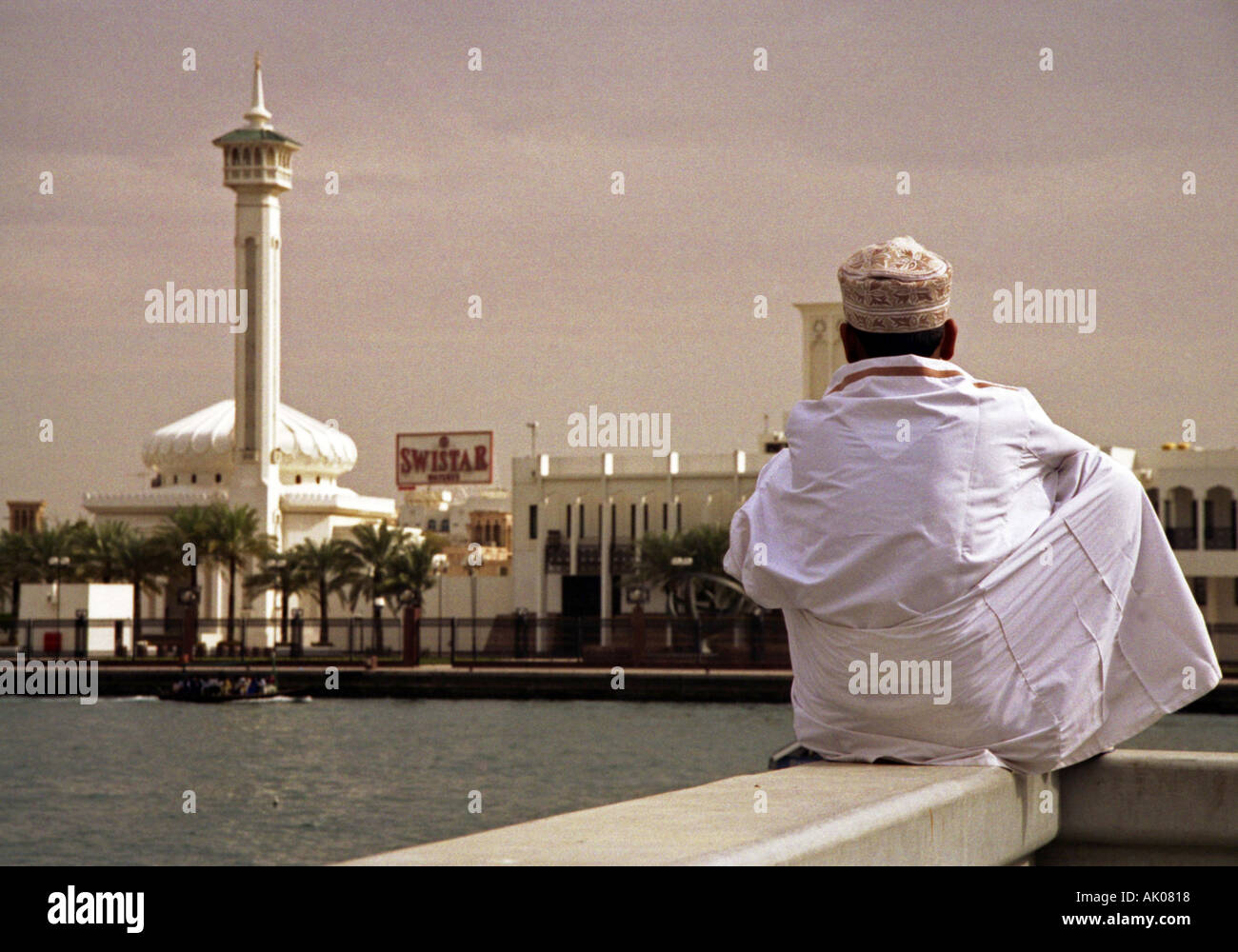 Arabic boy in elegant traditional clothing contemplate view by river ...