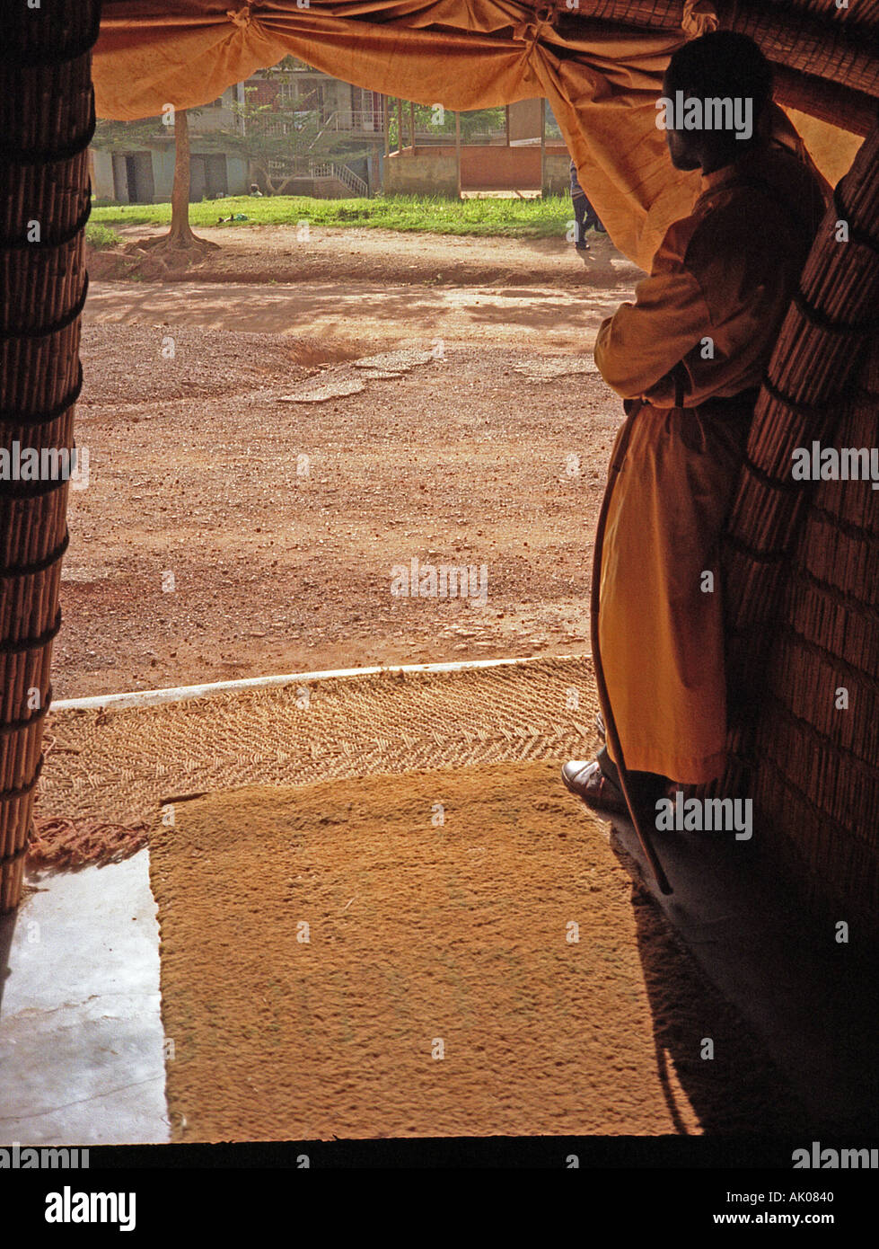 Entrance way of the Kasubi Tombs guarded by a man in traditional ...