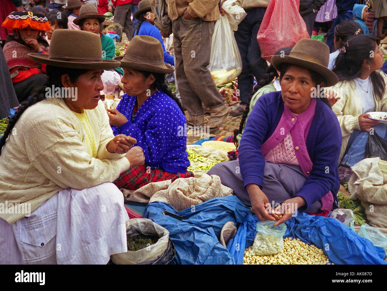 Indigenous peasant women in traditional colourful clothing hat sit sell ...