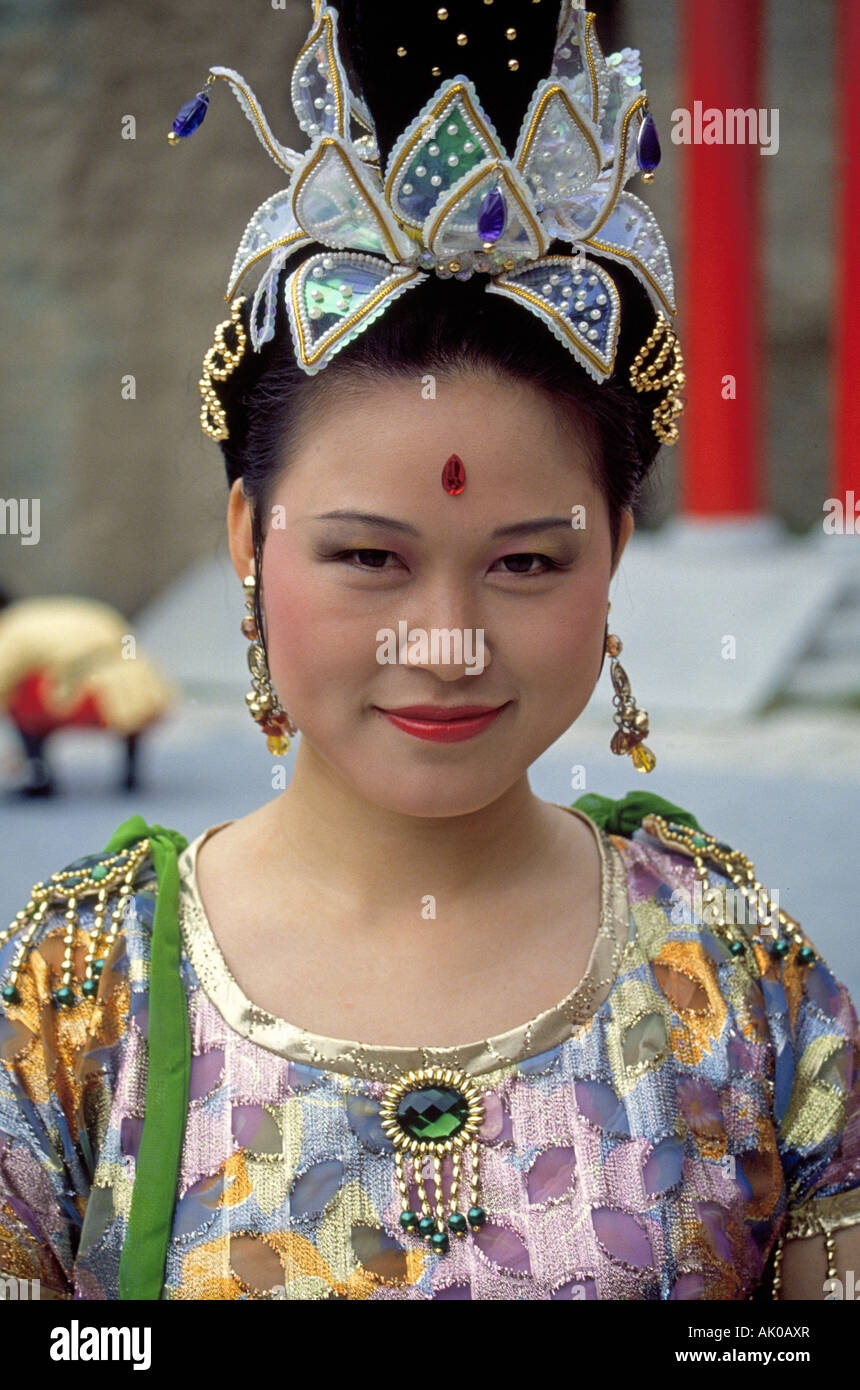A very pretty Chinese dancer prepares to dance in a dance troop at a ...