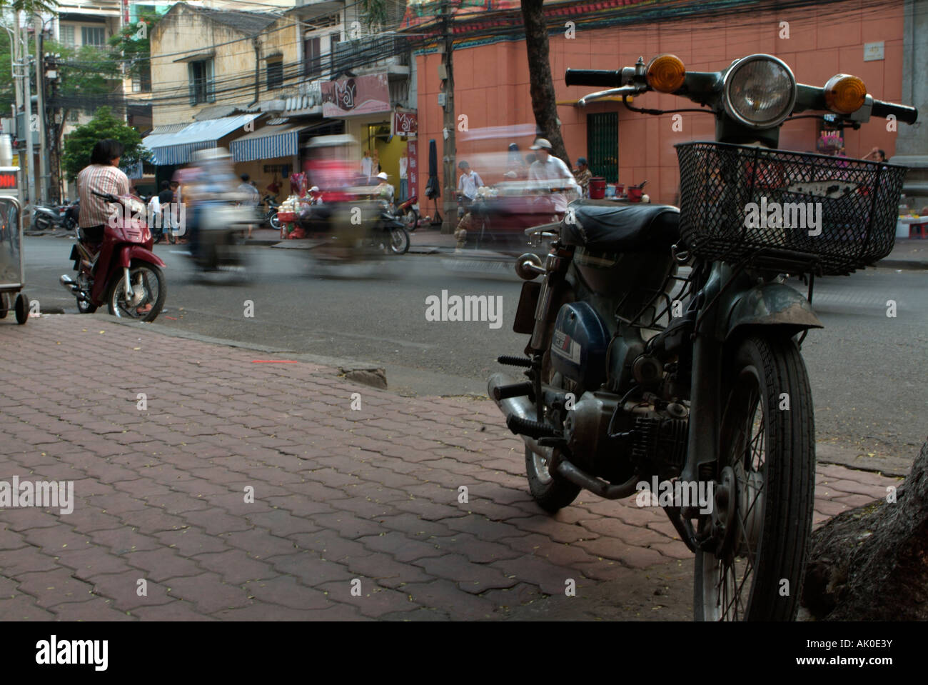 Static parked old motorbike beside a modern moped with a blurred ...