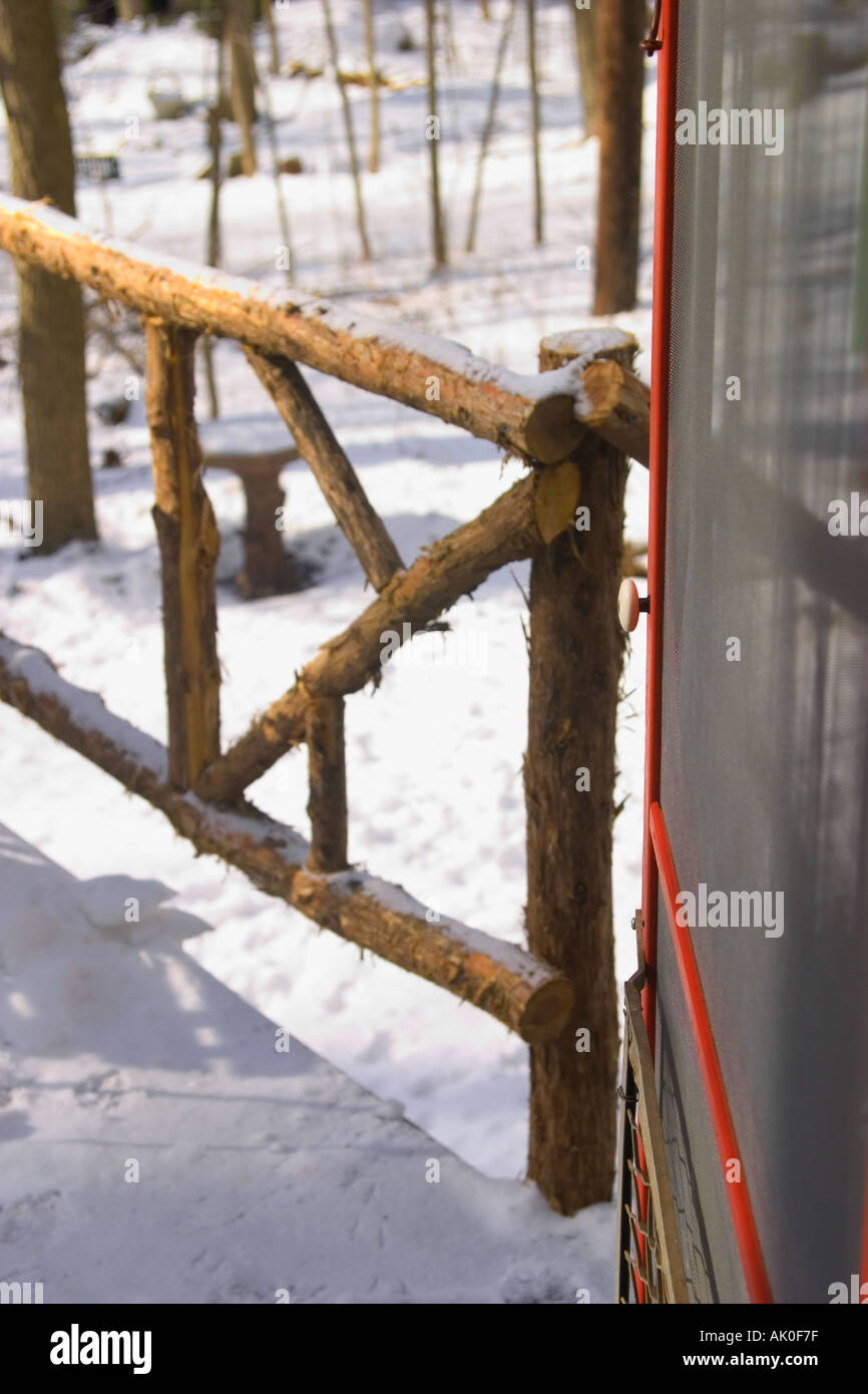Adirondack cabin screen door opening onto a deck with rustic railings ...