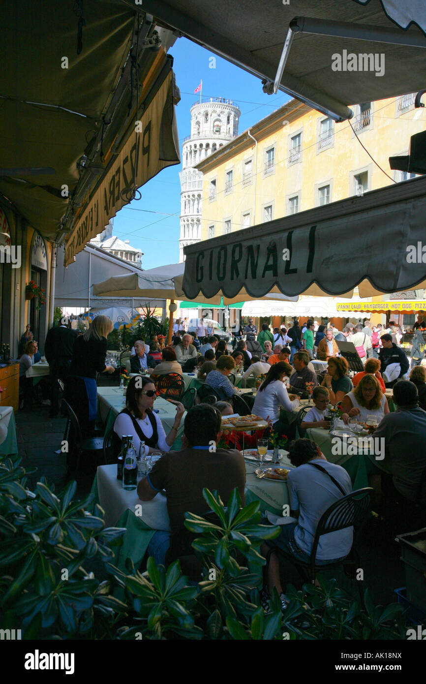 Tourists eating lunch and drinking in a shady Pisa restaurant cafe with ...