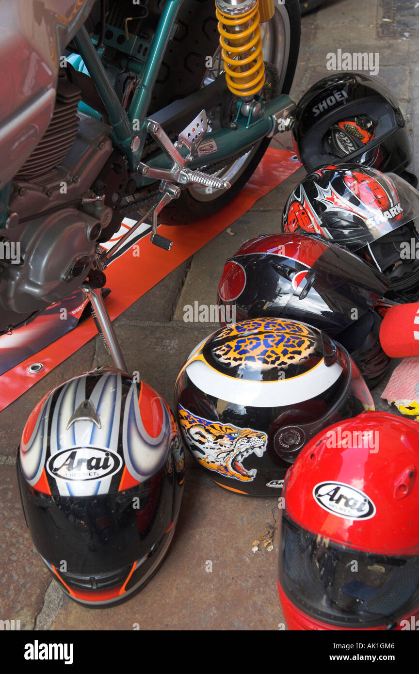 Group of motorcycle helmets on the ground next to bike wheel Stock ...