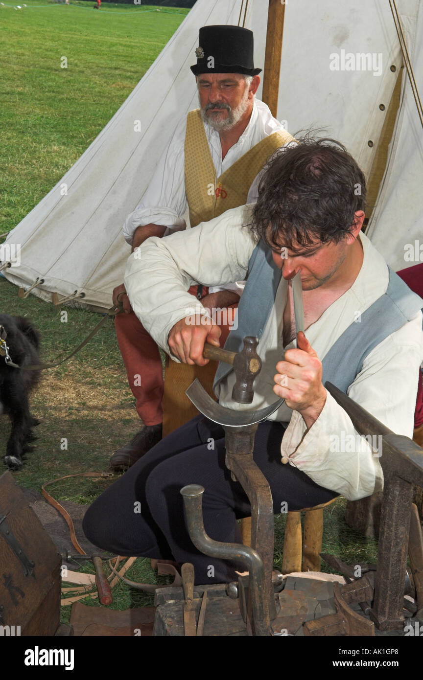 Blacksmith making arm plate for suit of armour in medieval reenactment ...