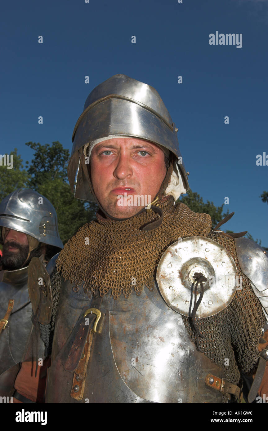 Closeup of man in suit of shining armour holding pike at medieval ...