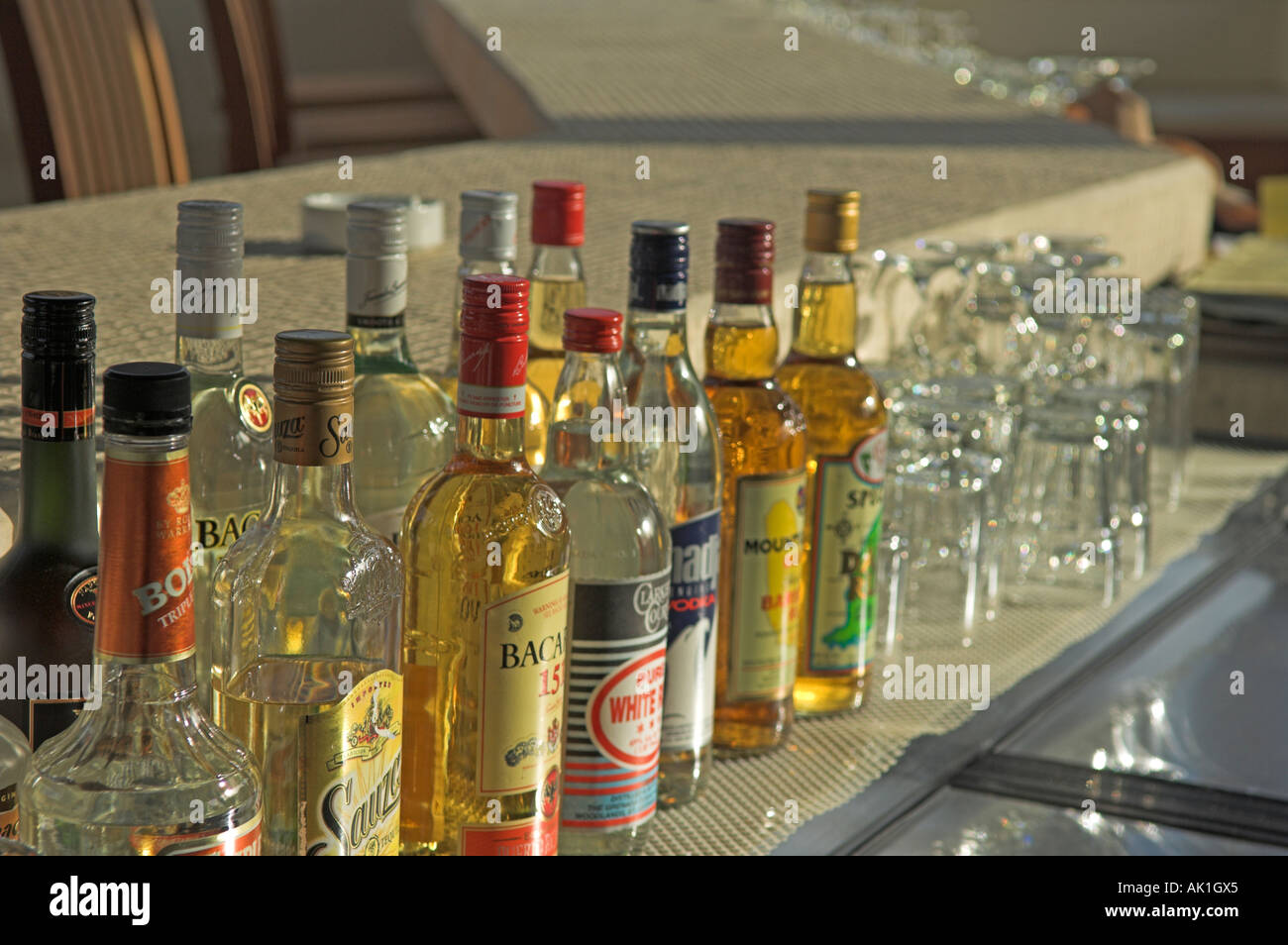 Bottles of spirits and glasses on bar counter Stock Photo - Alamy