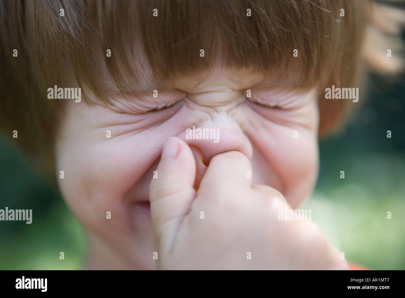 child holding nose and squinting Stock Photo - Alamy