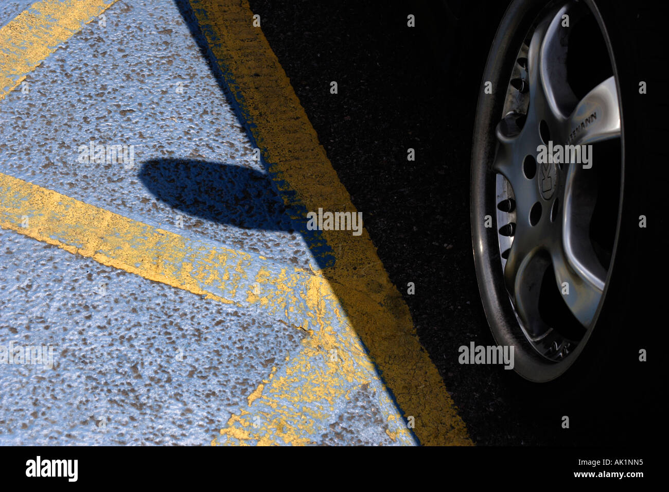 Detail of cars wheel stopped on yellow Keep Clear lines at road ...