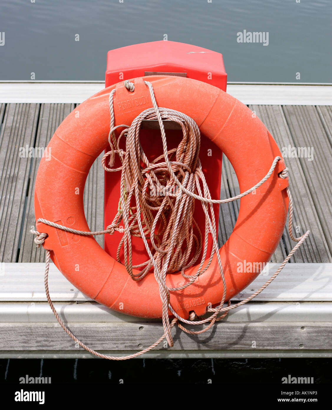 Life preserver with tangled rescue rope on marina quayside Stock Photo ...