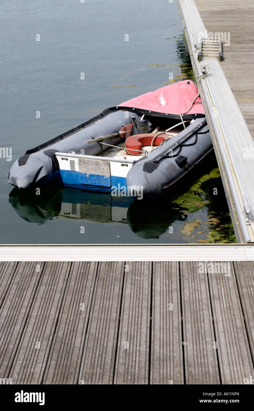 Partially deflated inflatable ships boat moored at marina quayside ...