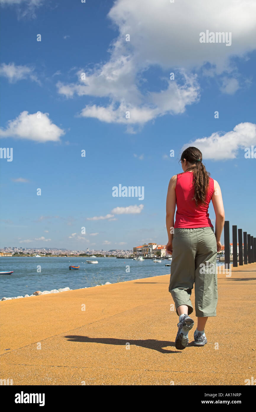 Young woman walking by seaside Stock Photo - Alamy