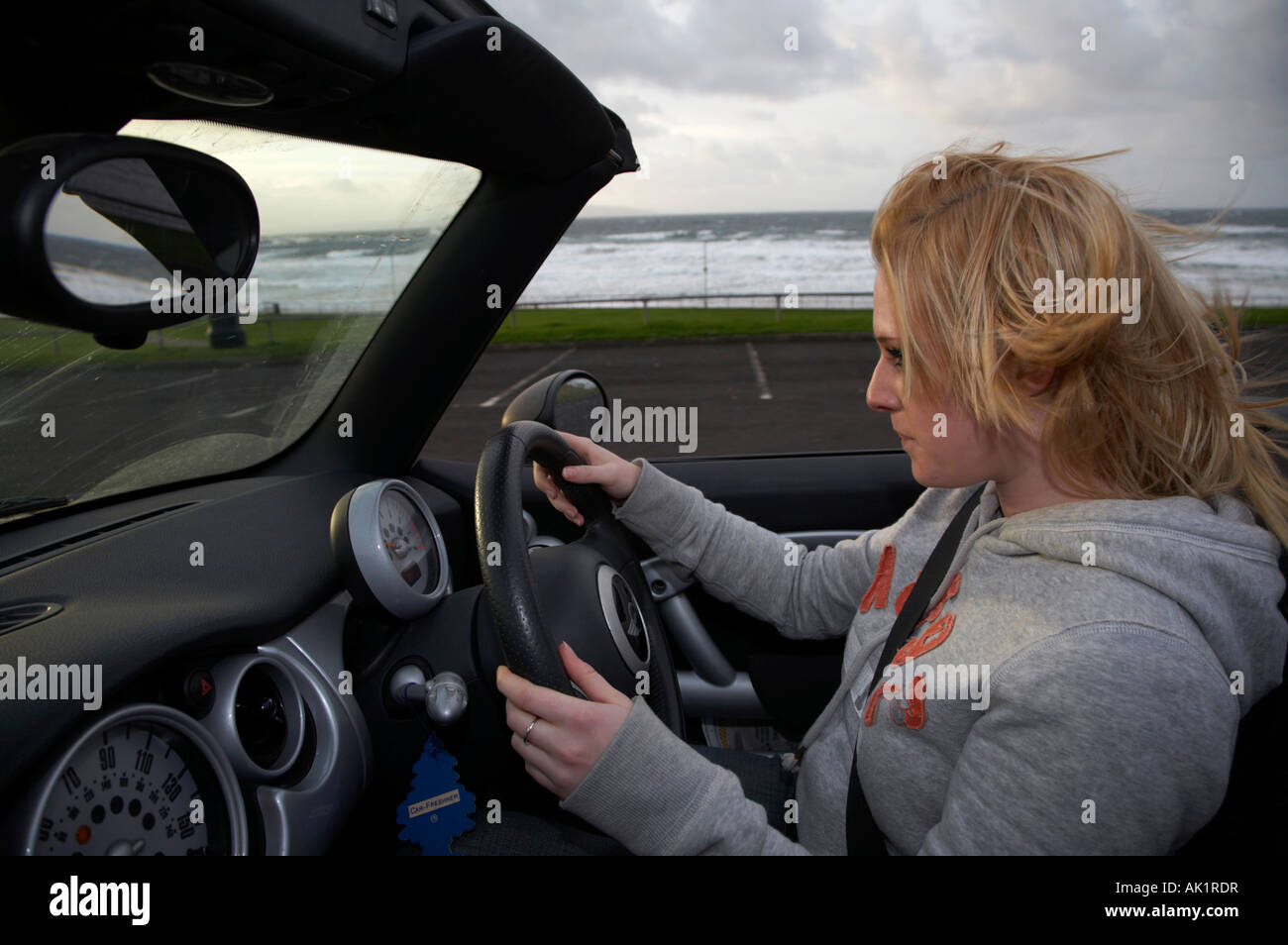 young blonde haired irish woman driving a mini convertible along the ...