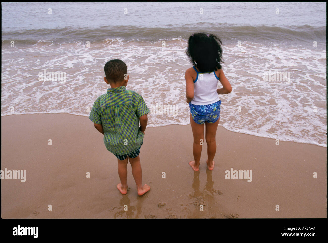 Two children wading into the sea Stock Photo - Alamy