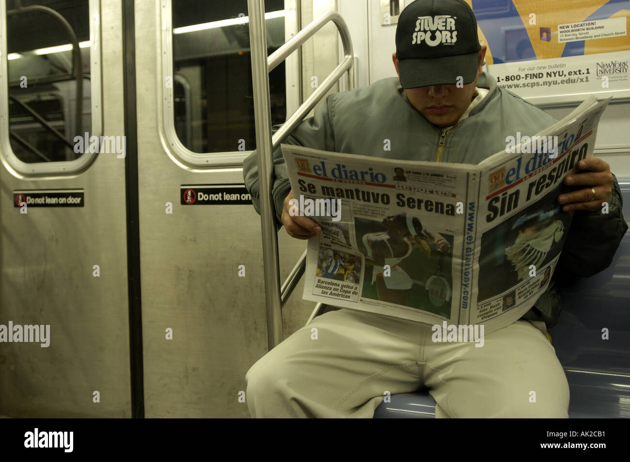 Reading NY Newspaper Subway horizontal Stock Photo - Alamy