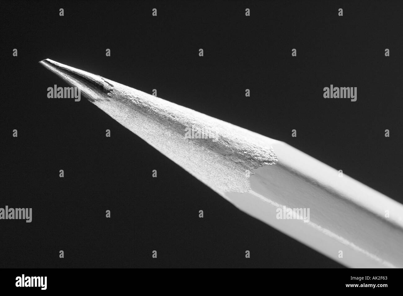 Yellow pencil point against black background Stock Photo - Alamy