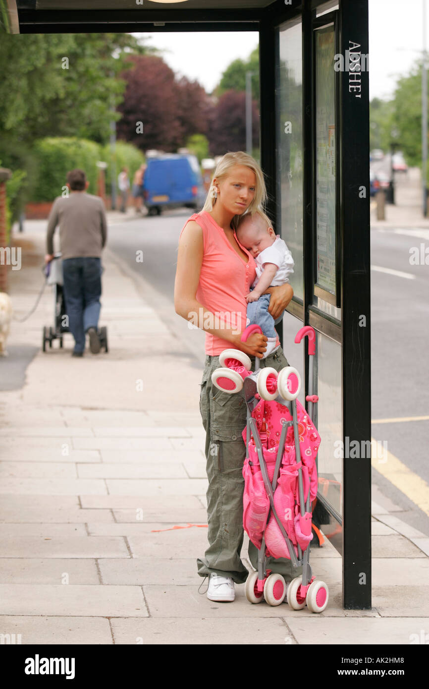 teenage mum at bus stop with baby and buggy Stock Photo - Alamy