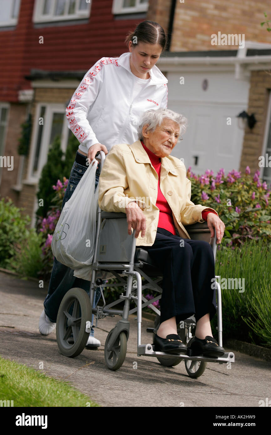 teenage girl pushing and elderly woman in a wheelchair Stock Photo - Alamy
