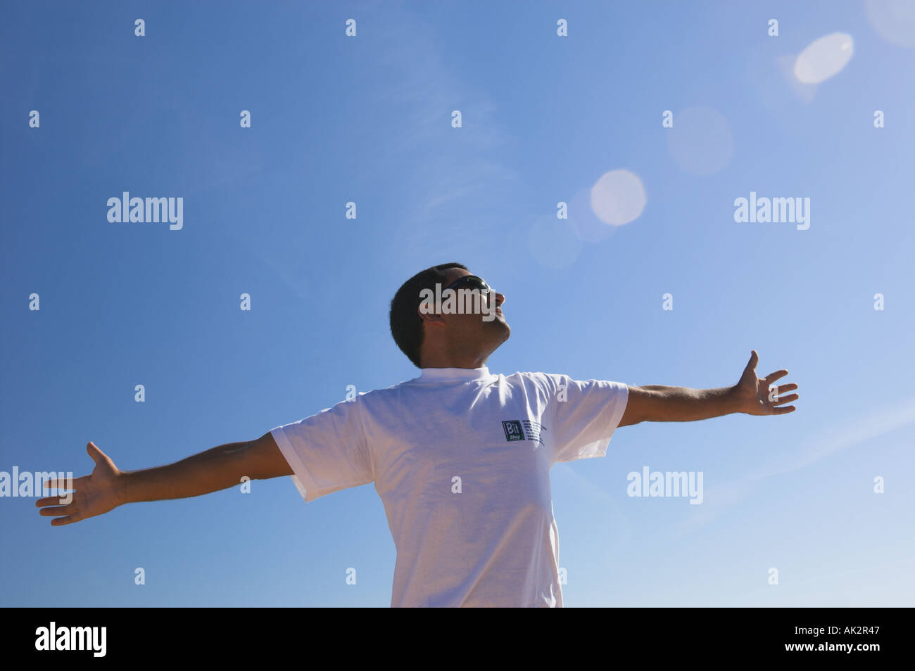 Man standing outside with arms open and facing the sun Stock Photo - Alamy