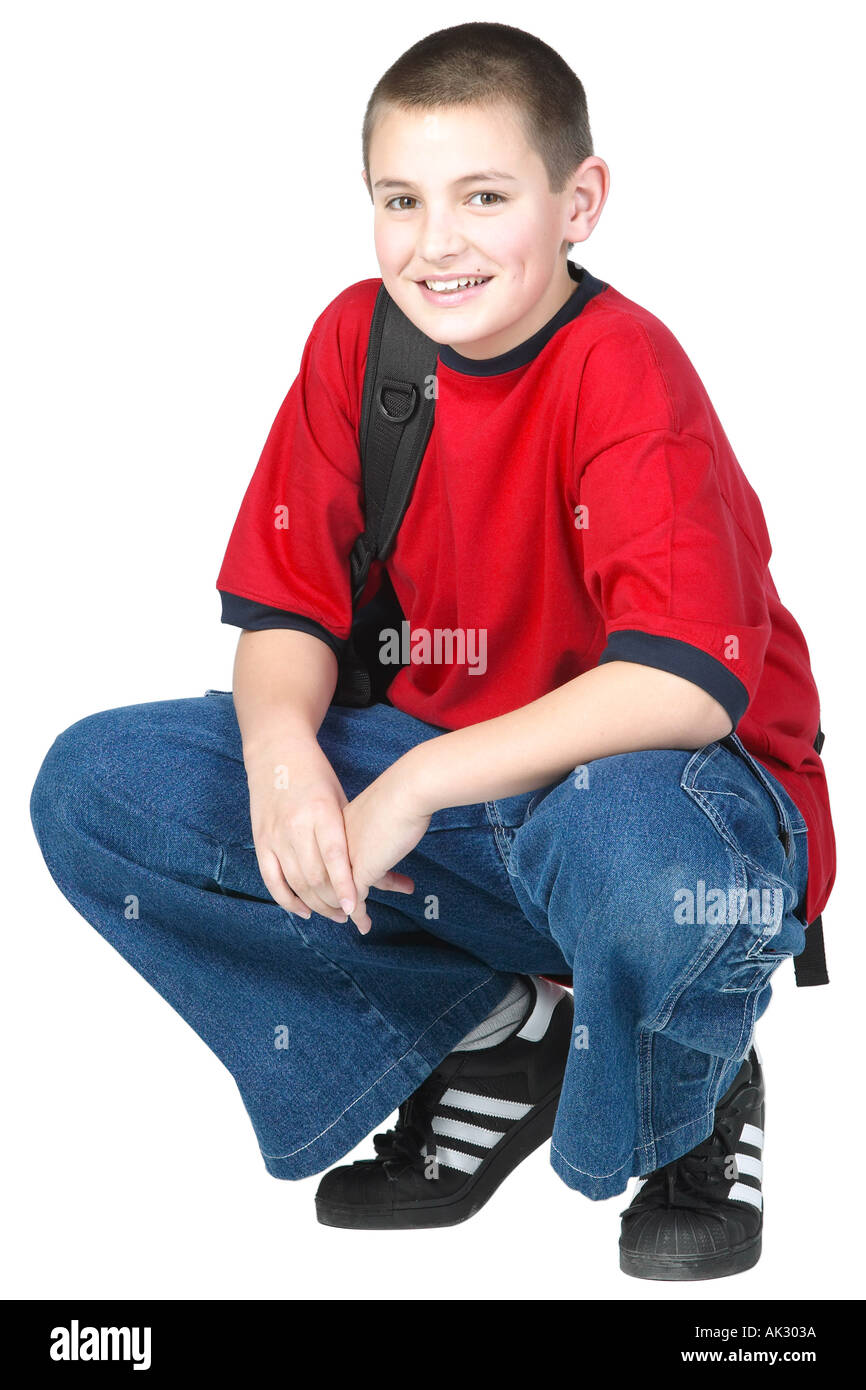Smiling little boy in jeans crouching on the ground Stock Photo - Alamy