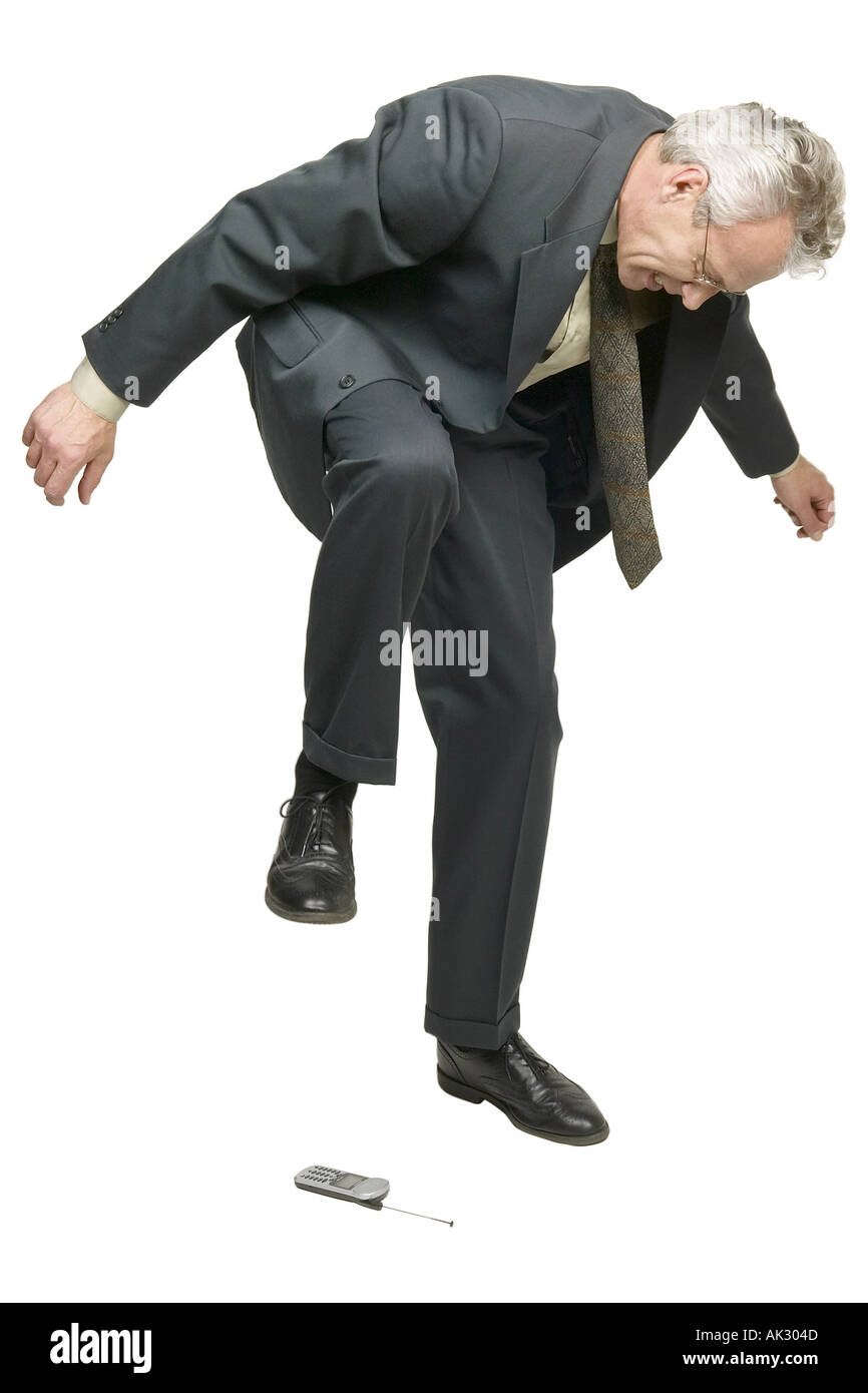 Frustrated businessman stepping on cell phone Stock Photo - Alamy