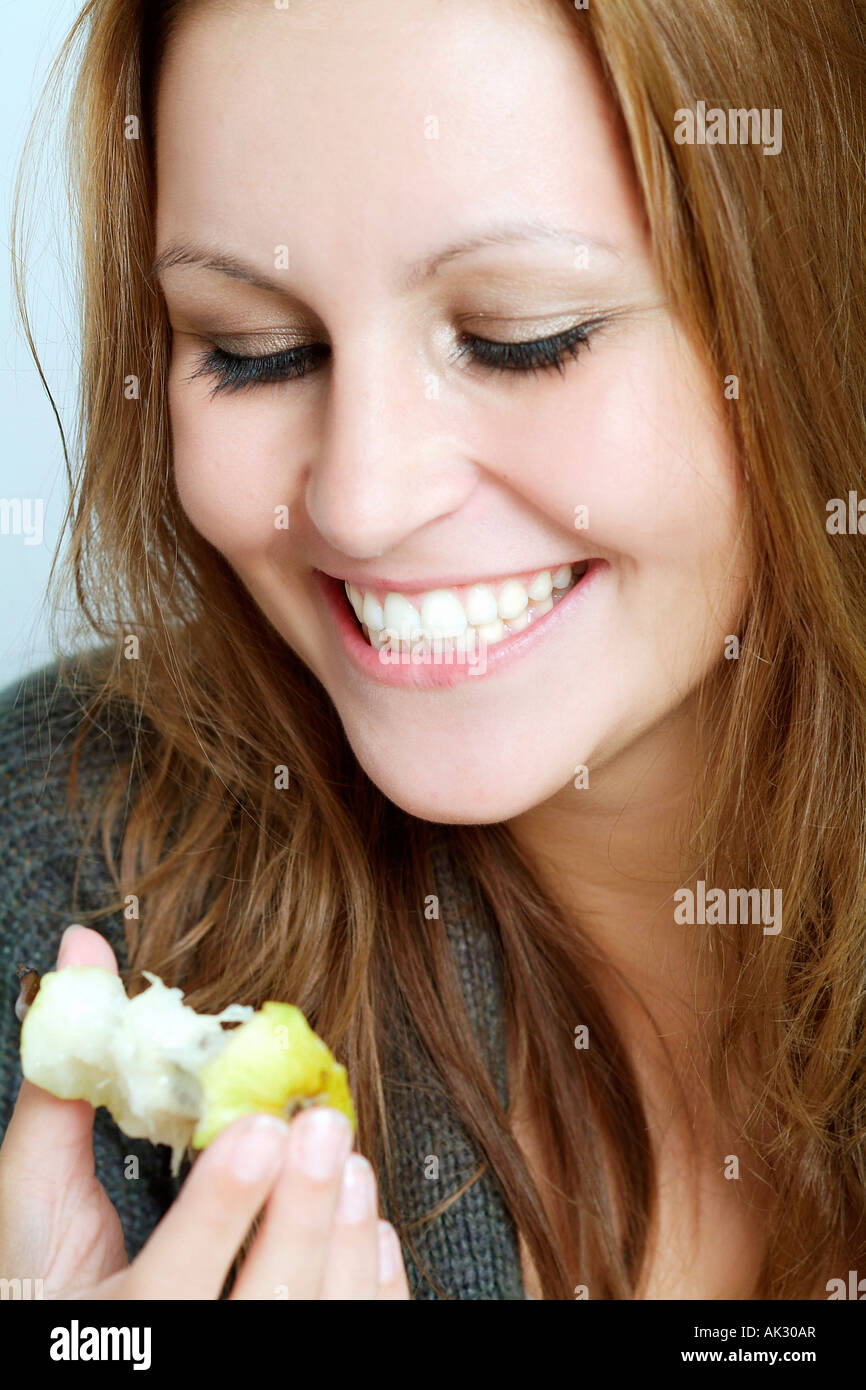 Young woman eating a pear Stock Photo - Alamy