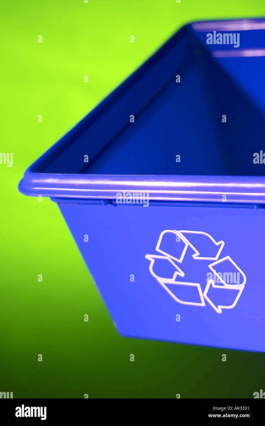 Blue plastic recycling box against green background Stock Photo - Alamy
