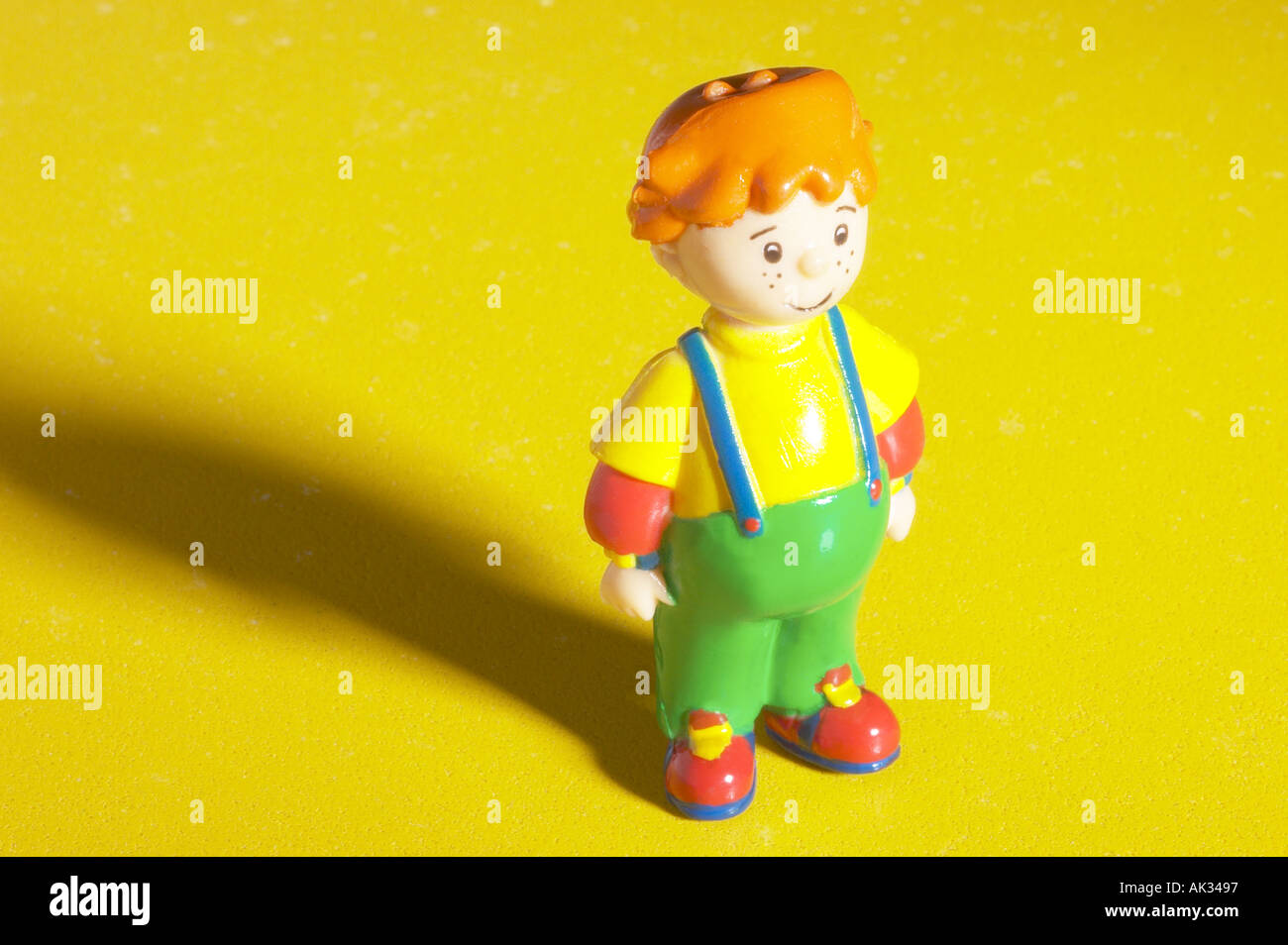 Plastic toy of redhead boy in overalls 1 Stock Photo - Alamy