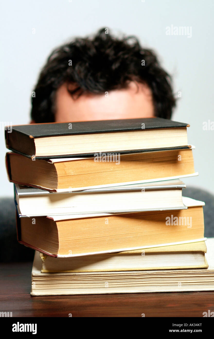 Man hidden behind books Stock Photo - Alamy