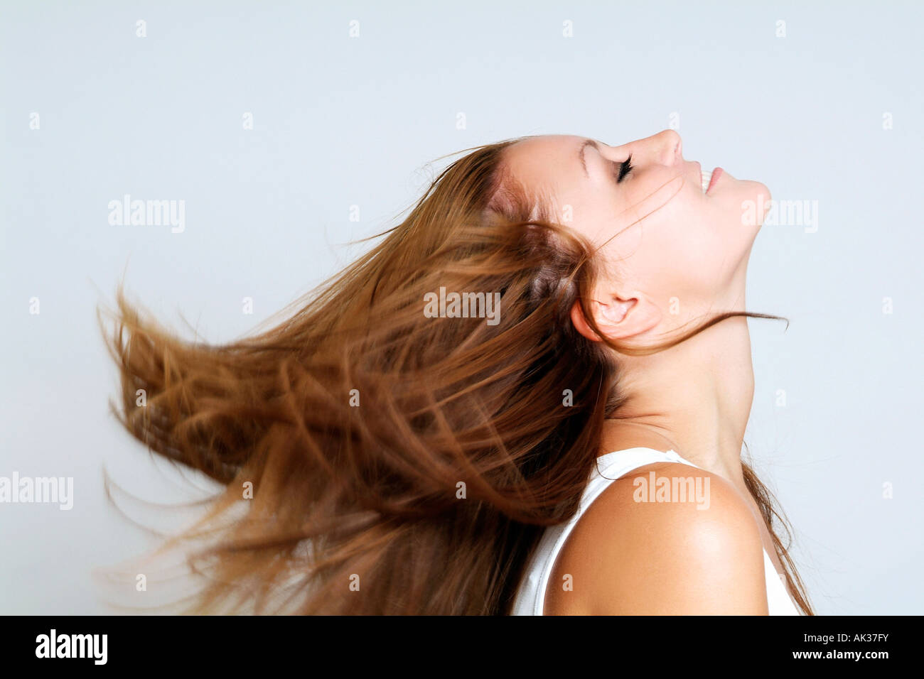 Young woman swinging her hair back Stock Photo - Alamy