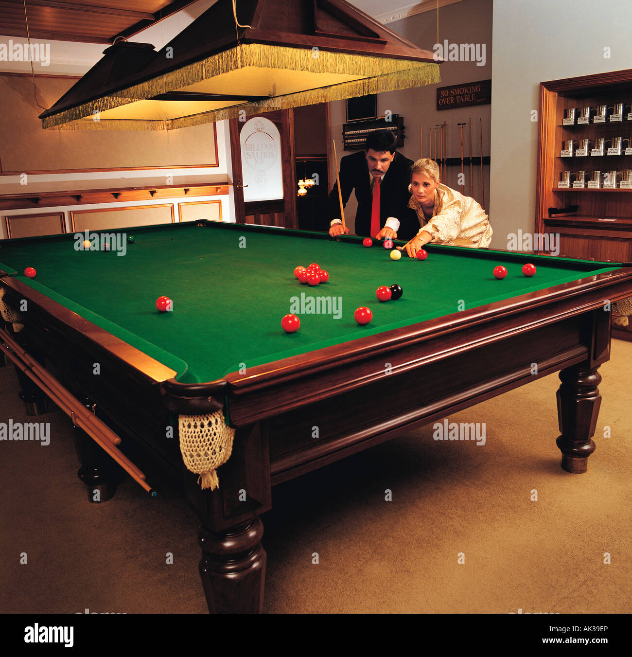Couple playing snooker in club room Stock Photo - Alamy