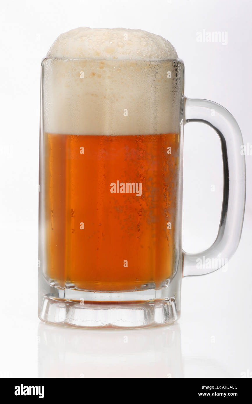 The beer in a glass mug with foam front view nobody on white table ...