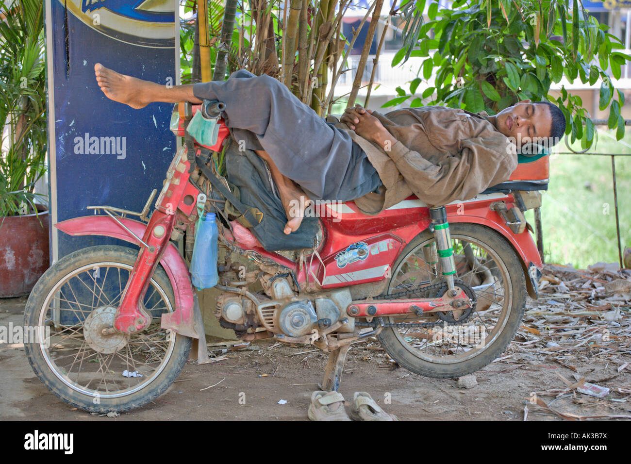 Man taking a nap on his motorcycle, Phnom Penh, Cambodia Stock Photo ...
